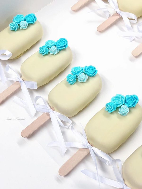 White Chocolate Coated Cake Popsicles with Blue Sugar Flowers – Soiree